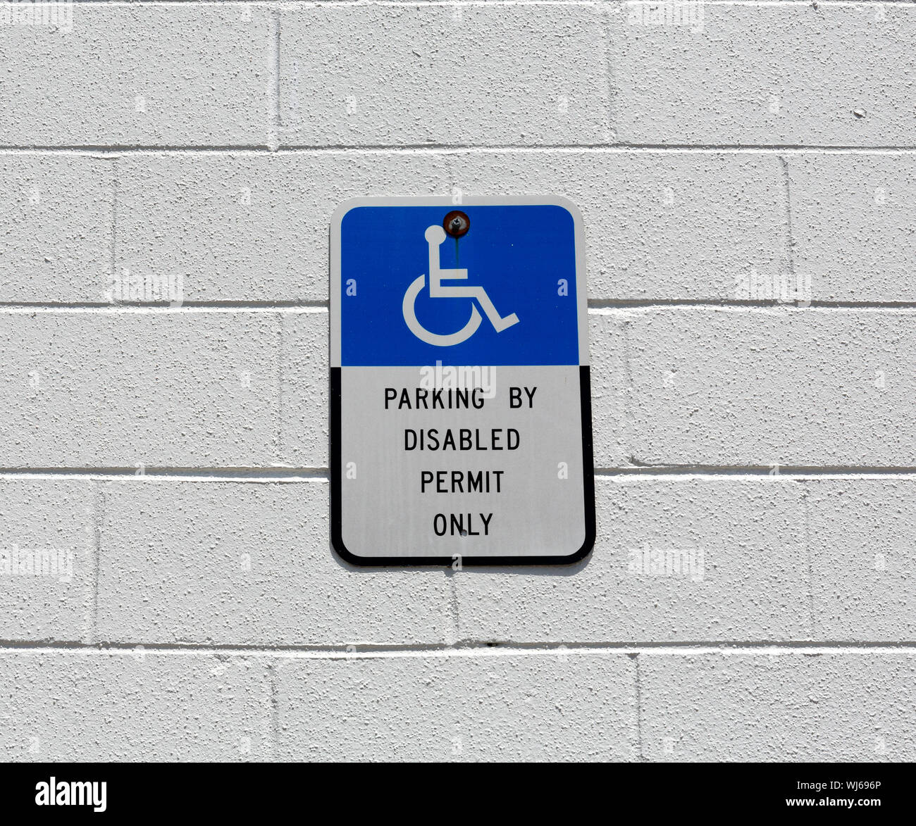 Blue and white handicap disabled parking sign bolted to a painted ...
