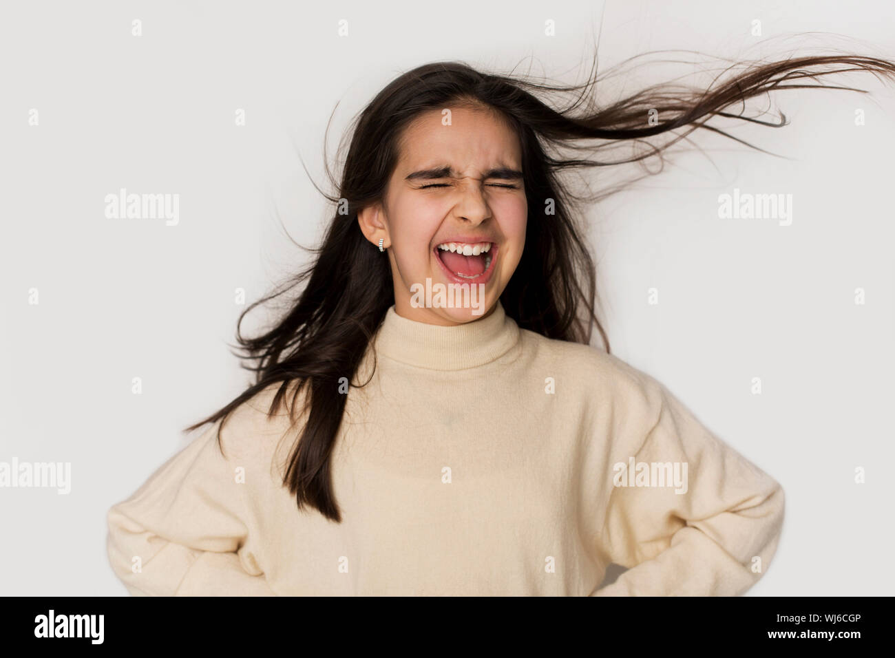 Joyful school girl shouting over light background Stock Photo - Alamy
