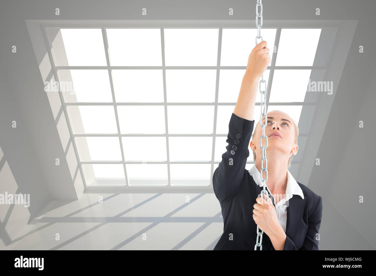Composite image of blonde businesswoman pulling a chain Stock Photo - Alamy