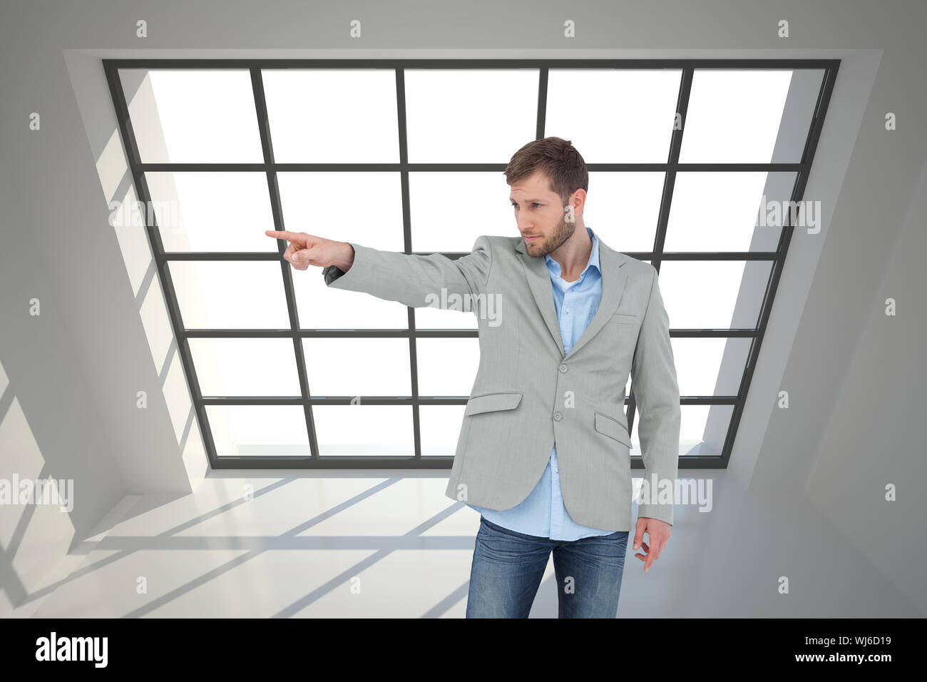 Composite image of trendy model pointing to something Stock Photo - Alamy