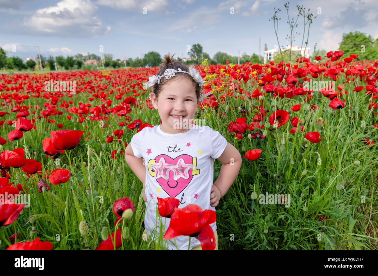 Beautiful kid in poppy field in the summer months.She is smile Stock ...