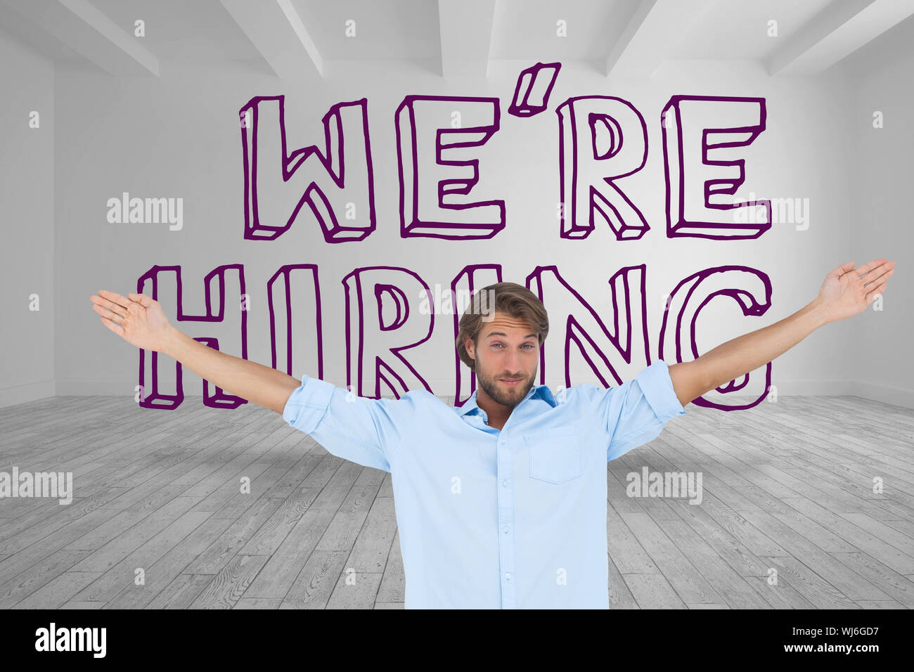 Handsome man raising arms in front of were hiring graphic in a grey ...