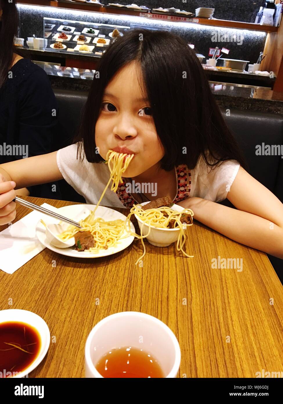 Girl eating noodles hi-res stock photography and images - Alamy