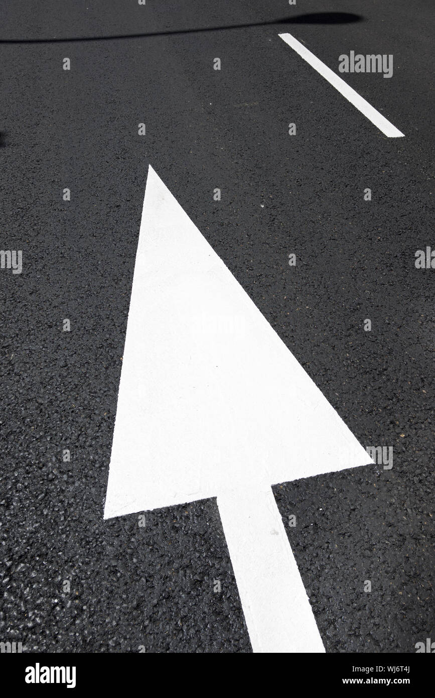 Single arrow directional sign on the floor Stock Photo - Alamy