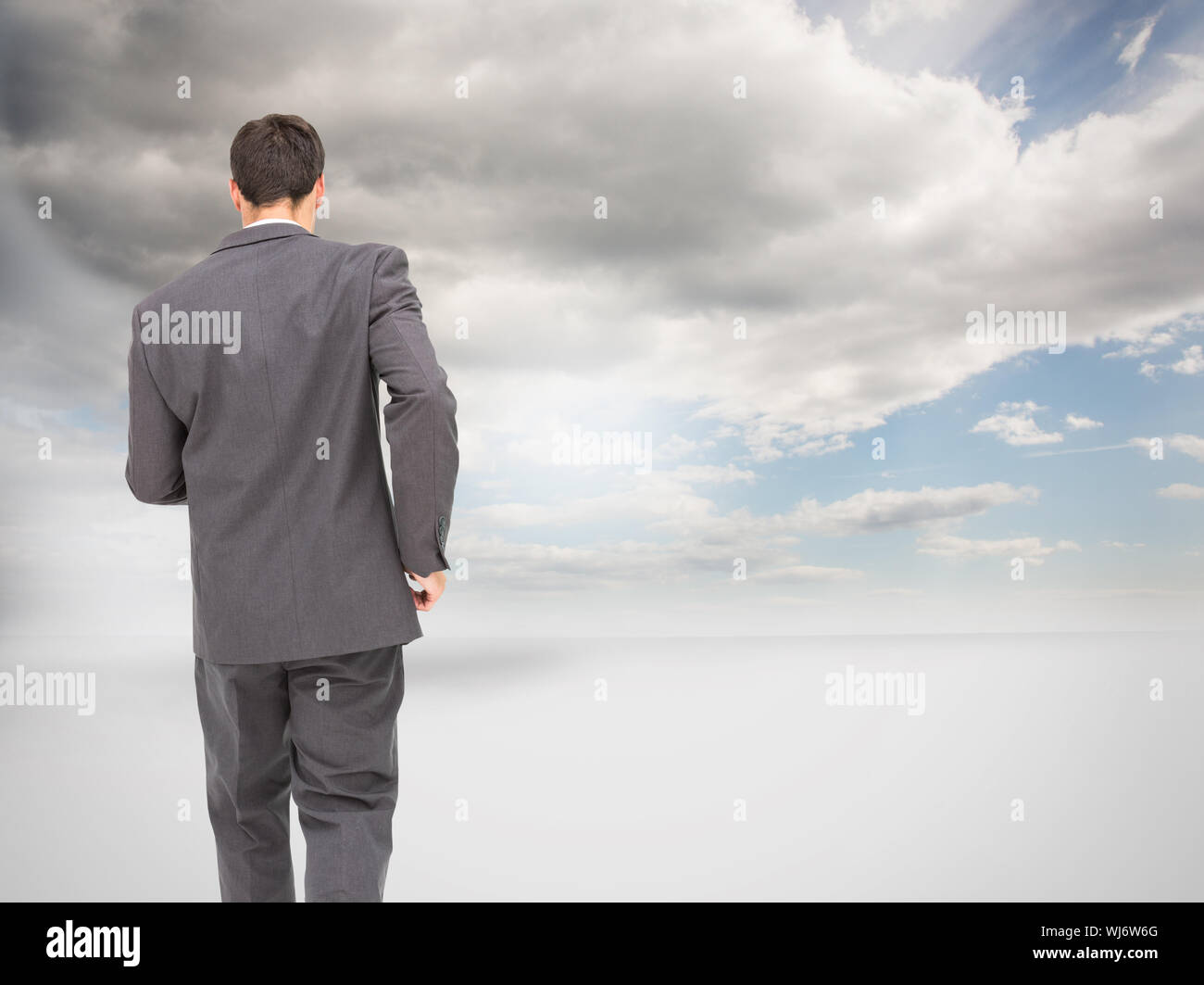 Composite image of young businessman walking away from camera on white ...