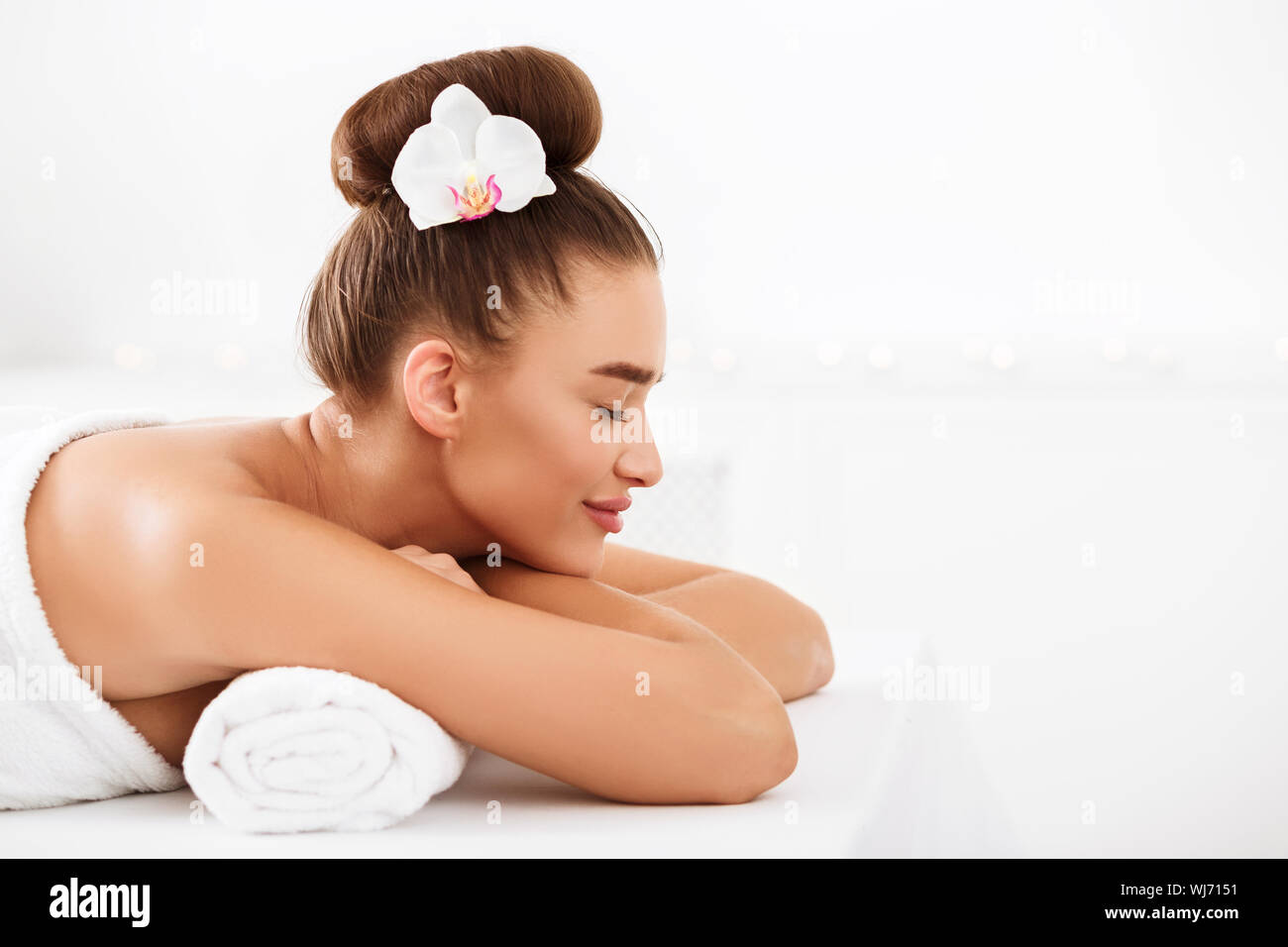 Beautiful girl relaxing at light spa salon, side view Stock Photo - Alamy
