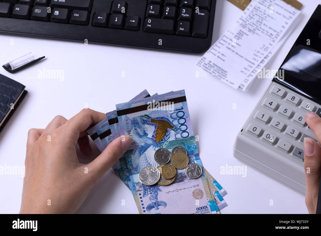 Tenge at the cashier accountant in the hands of the workplace in the ...