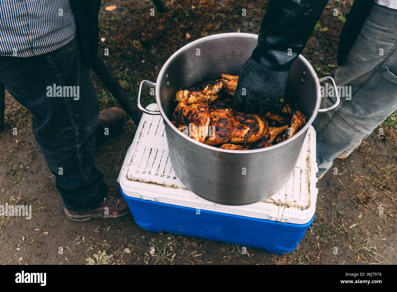 Low Section Of Men With Meat In Container On Field Stock Photo - Alamy