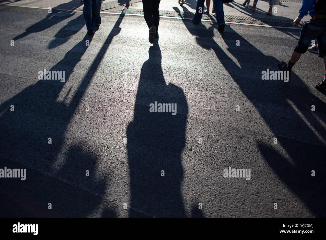 Crowd walking in shadow hi-res stock photography and images - Alamy