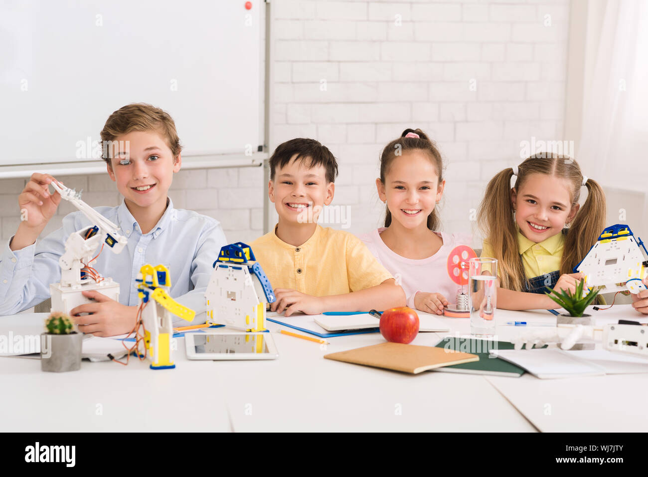 Happy children creating robots at stem class Stock Photo - Alamy