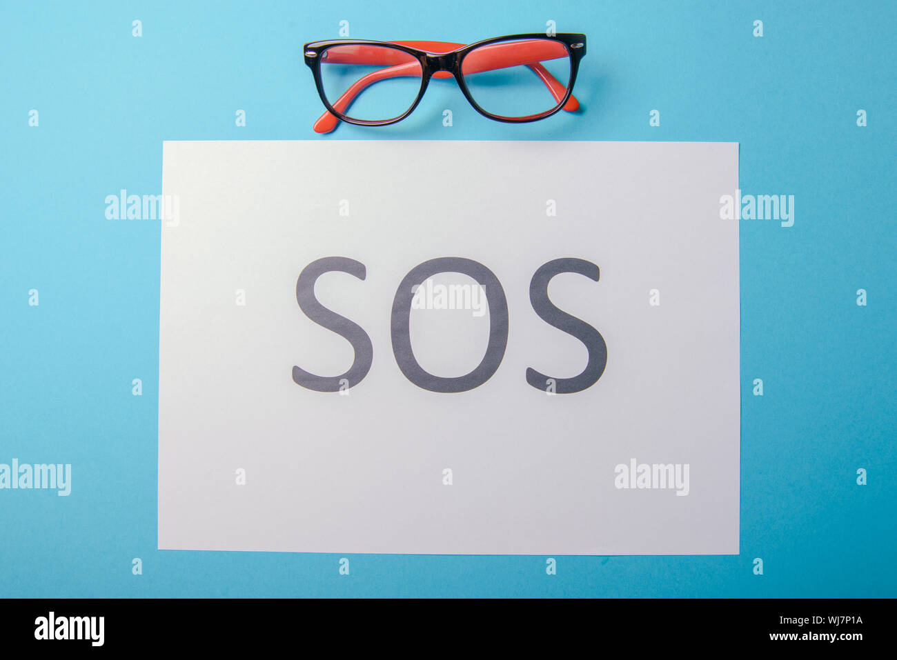 Word SOS written on white paper. Blue background Stock Photo - Alamy