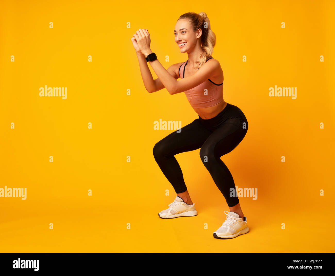 Millennial Girl Doing Deep Squat Exercise On Yellow Background Stock ...