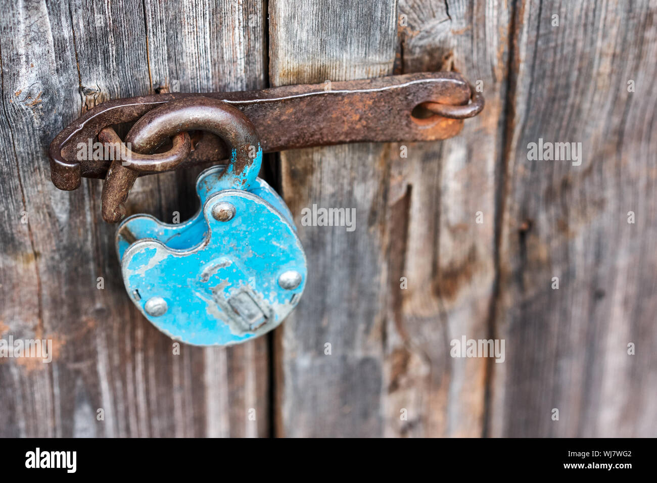 Blue old rusty unlocked padlock on wooden door Stock Photo - Alamy