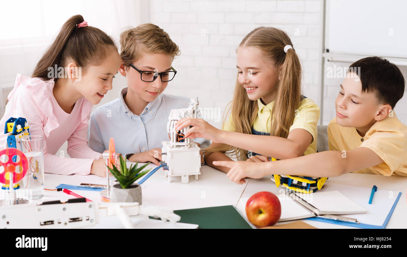 Stem education. Classmates creating modern robots in classroom Stock ...