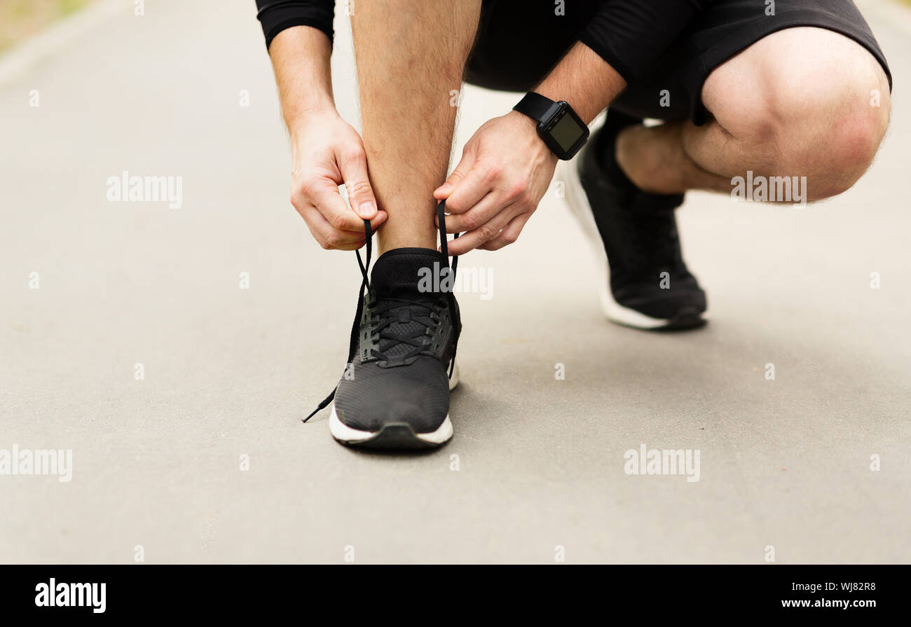 Man tying running shoes laces getting ready for run Stock Photo - Alamy