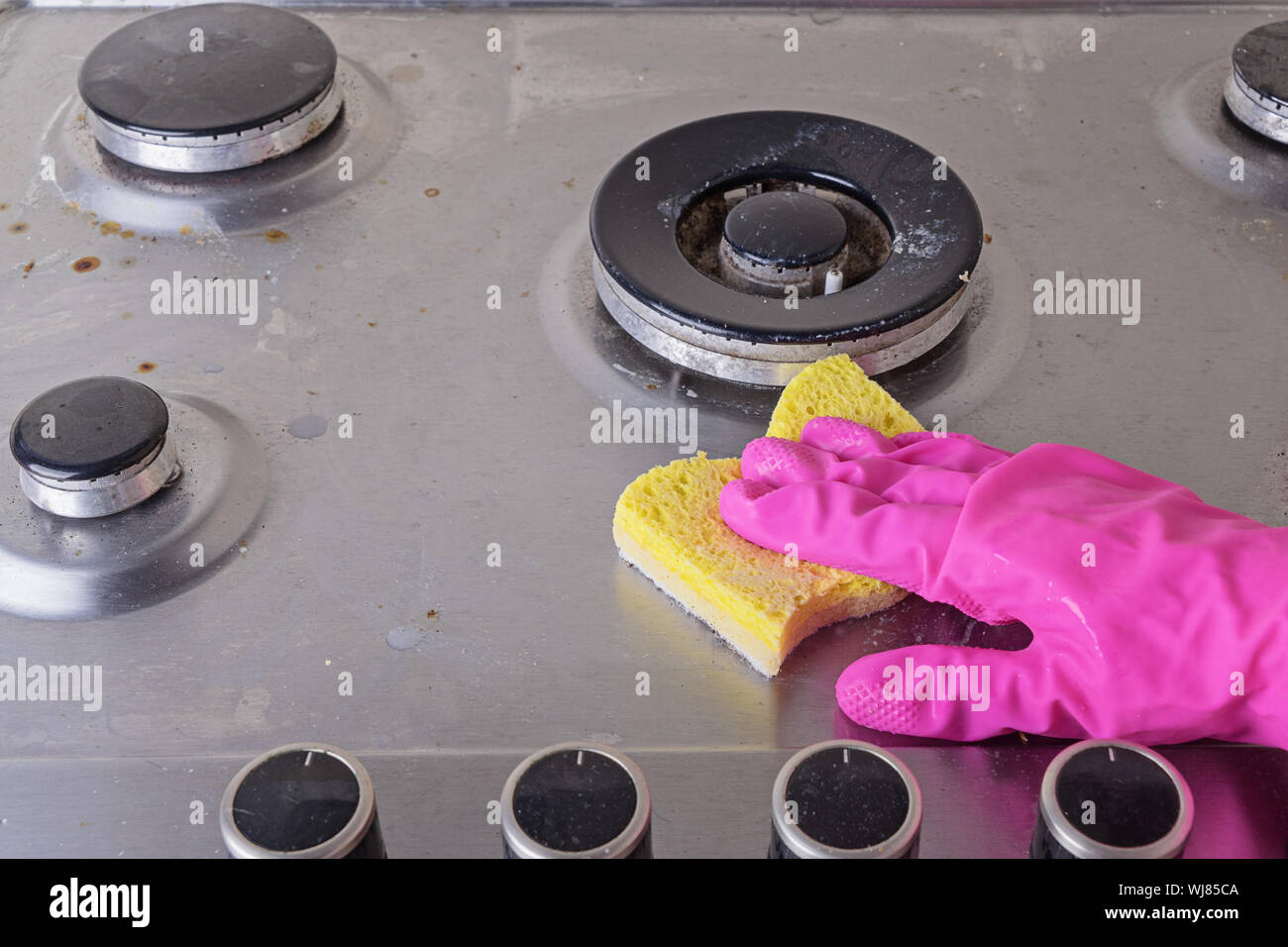Manual Cleaning of stainless steel gas stove with scrub and sponge ...