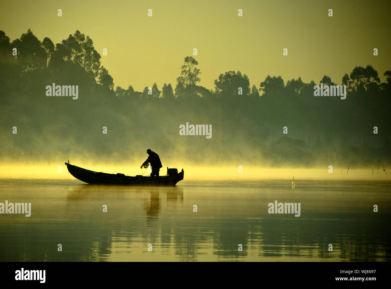 The boatman fishing on a lake Stock Photo - Alamy