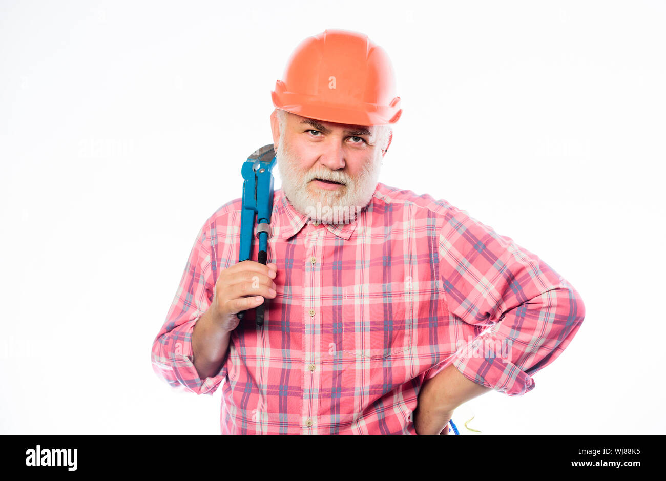 Man bearded plumber wear helmet and hold wrench tool. Repair concept ...