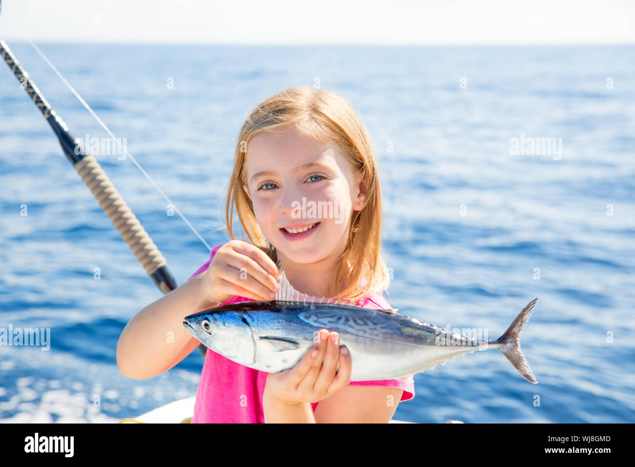 Blond kid girl fishing tuna little tunny happy with trolling catch on ...