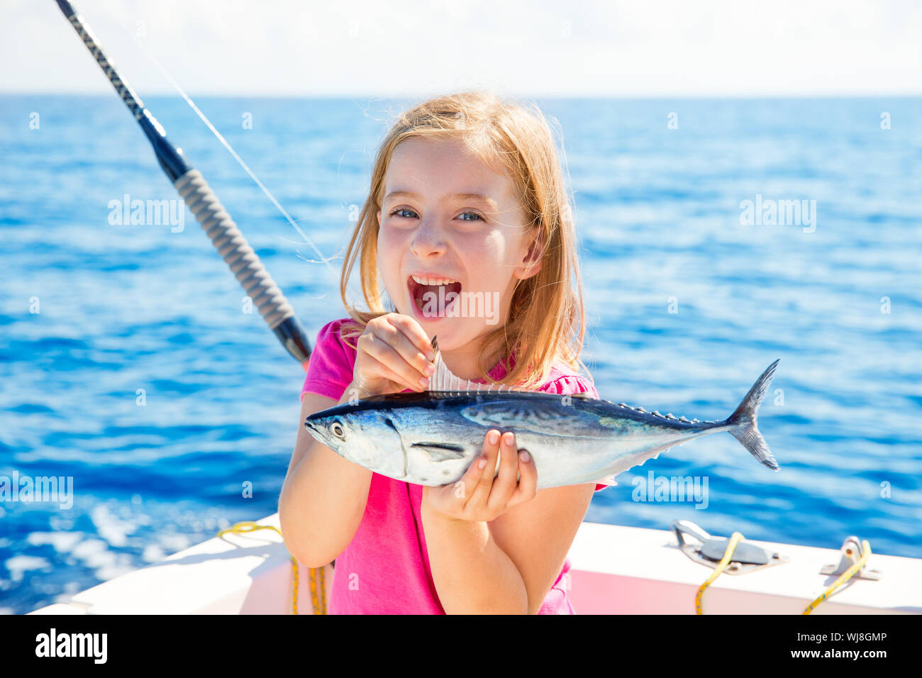 Blond kid girl fishing tuna little tunny happy with trolling catch on ...
