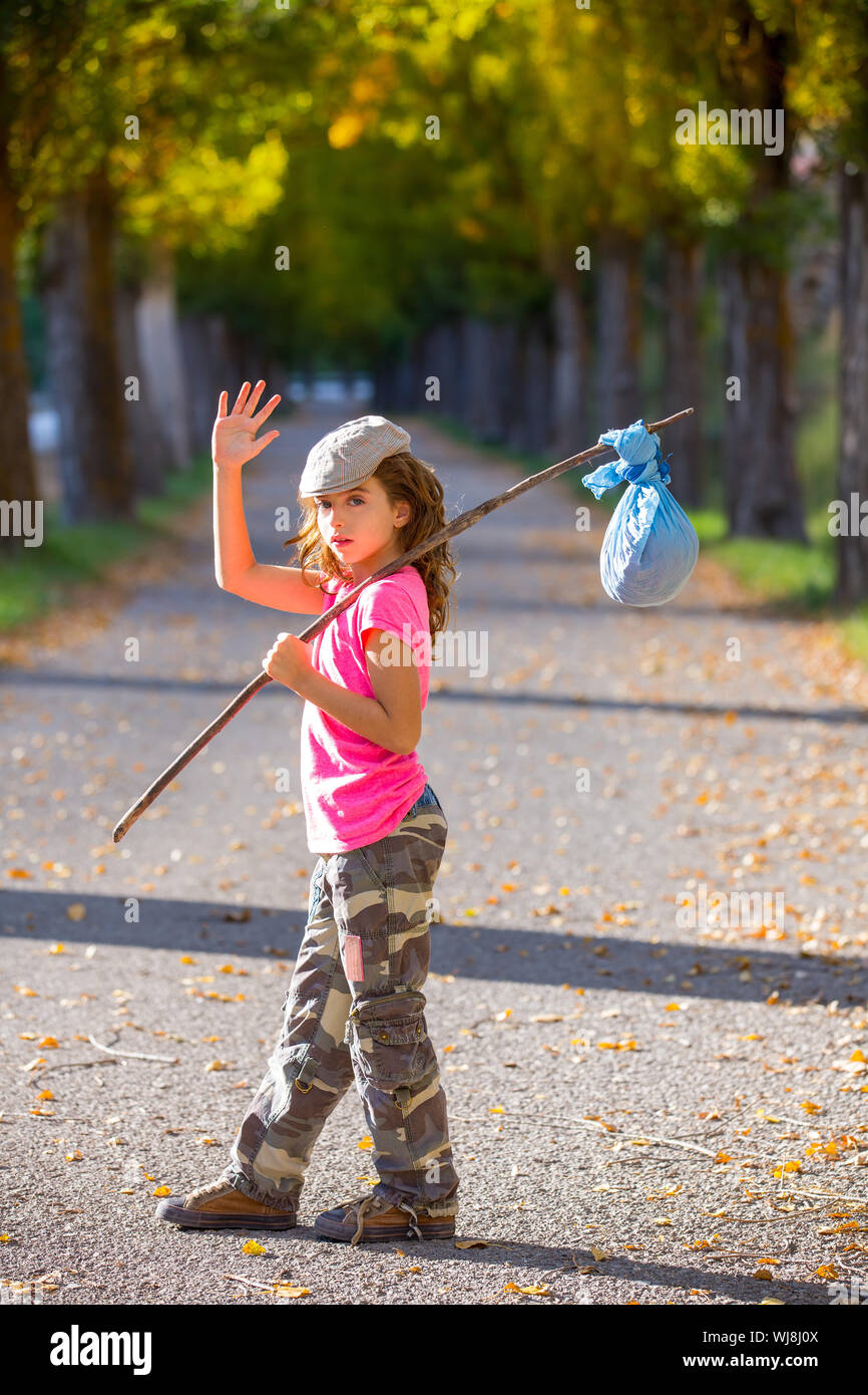 little kid with hobo stick bag and bundle girl saying goodbye with hand ...