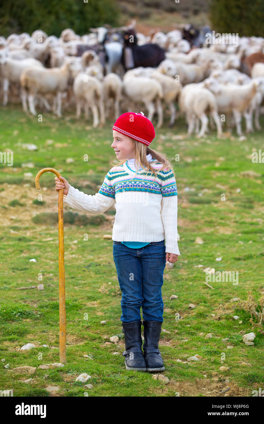 Kid girl shepherdess happy with flock of sheep and wooden stick in ...