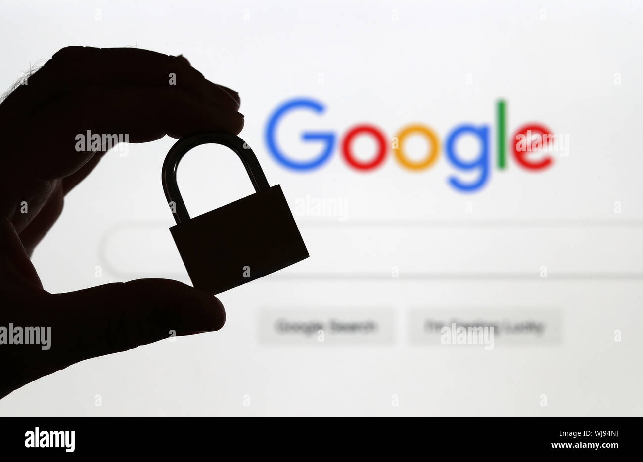 A man holding a padlock infront of a computer screen displaying the ...