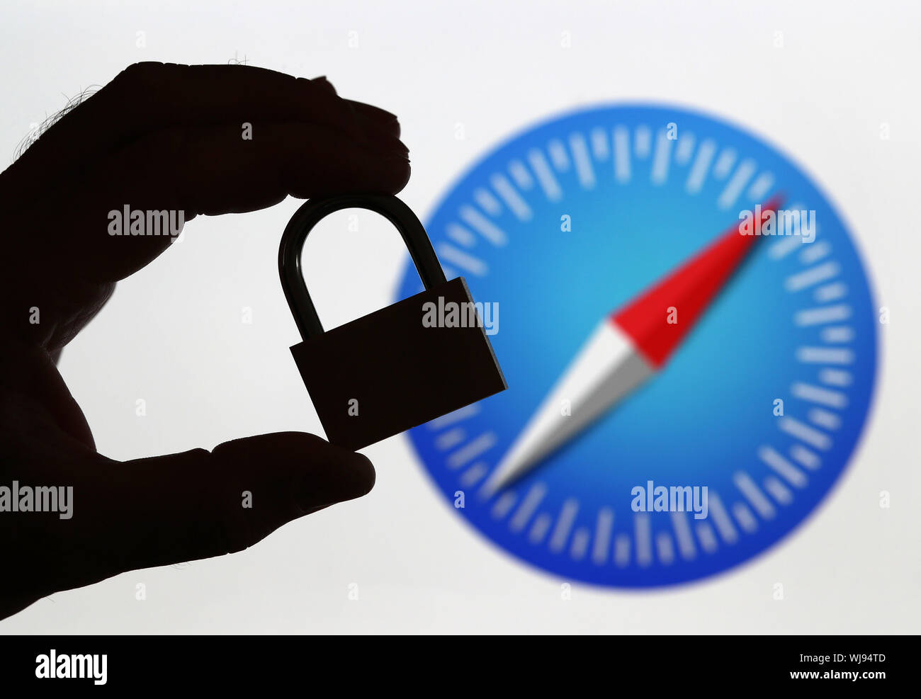 A man holding a padlock infront of a computer screen displaying the ...