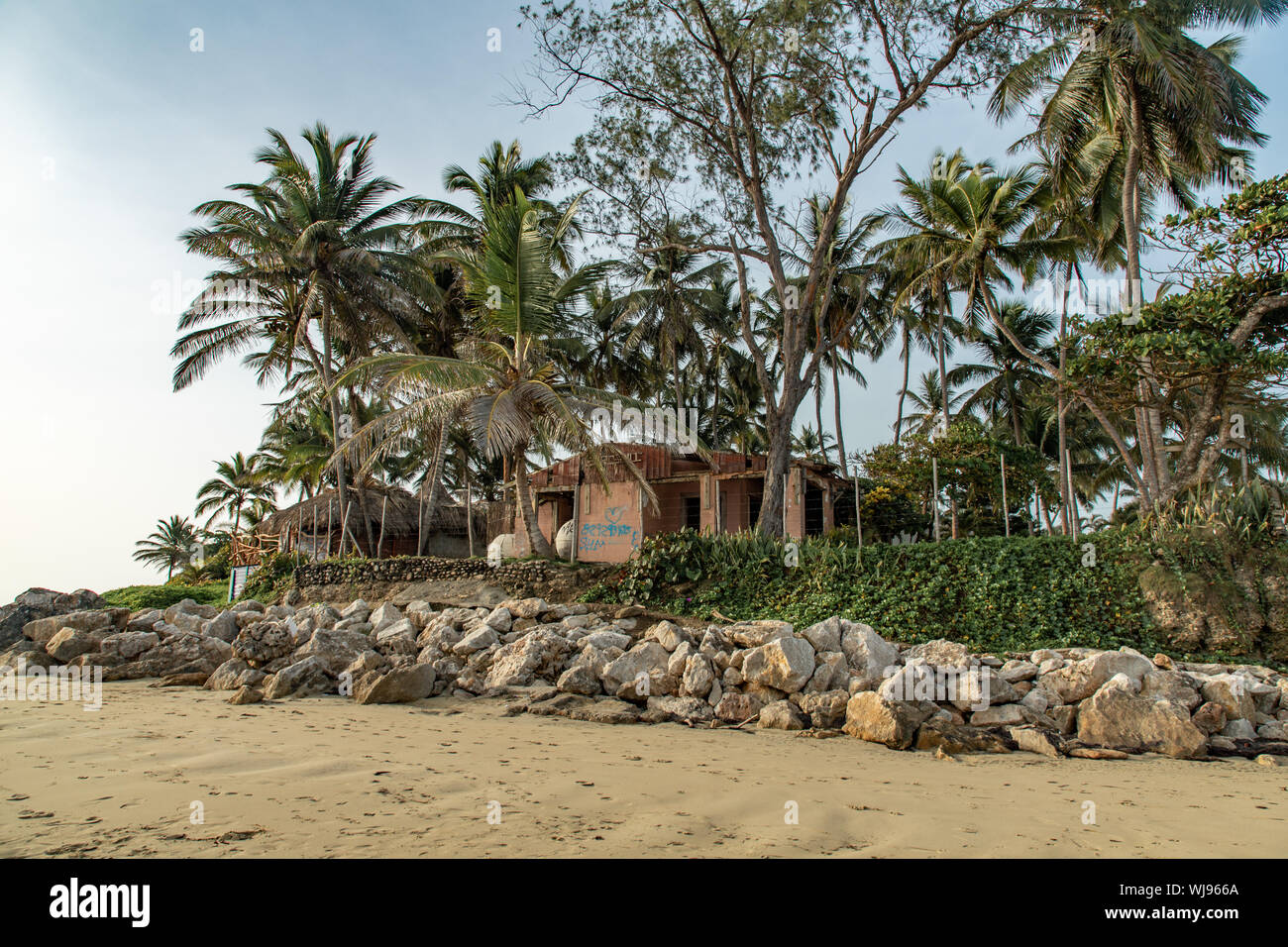 Beach poor huts, shacks among palm trees at tropical sunrise, Cabarete ...