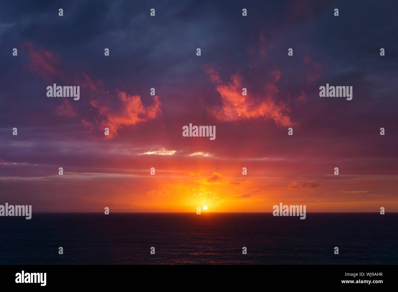 beautiful red dusk over the sea with sun rays Stock Photo - Alamy