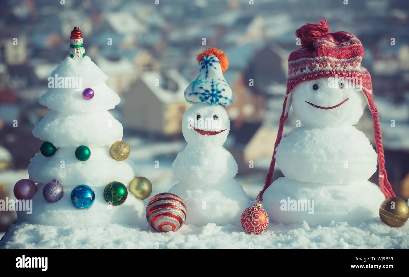 Snowmen with smiley faces in hats on winter day Stock Photo - Alamy