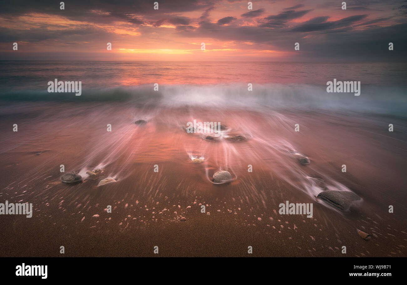 long exposure seascape with rocks and waves on beach Stock Photo - Alamy