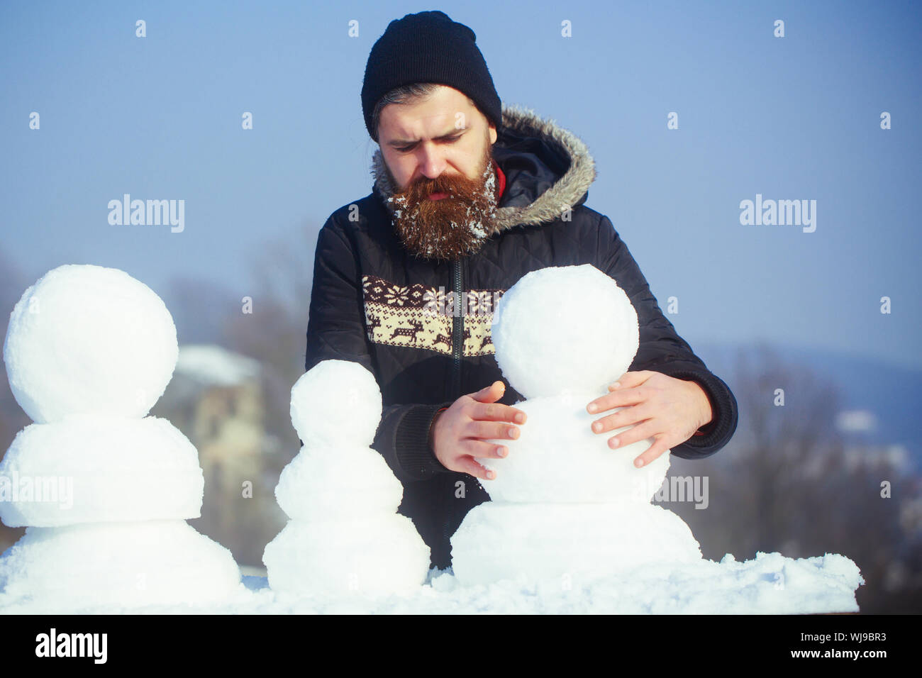 christmas man in hat with long beard make snowman Stock Photo - Alamy