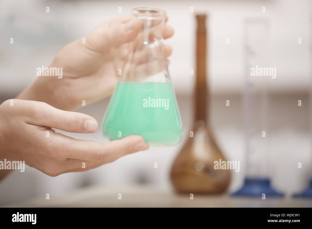 Hand of laboratory technician holding flask with chemical Stock Photo ...