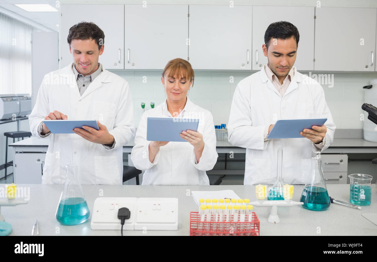 Group of serious scientists using tablet PCs in the laboratory Stock ...