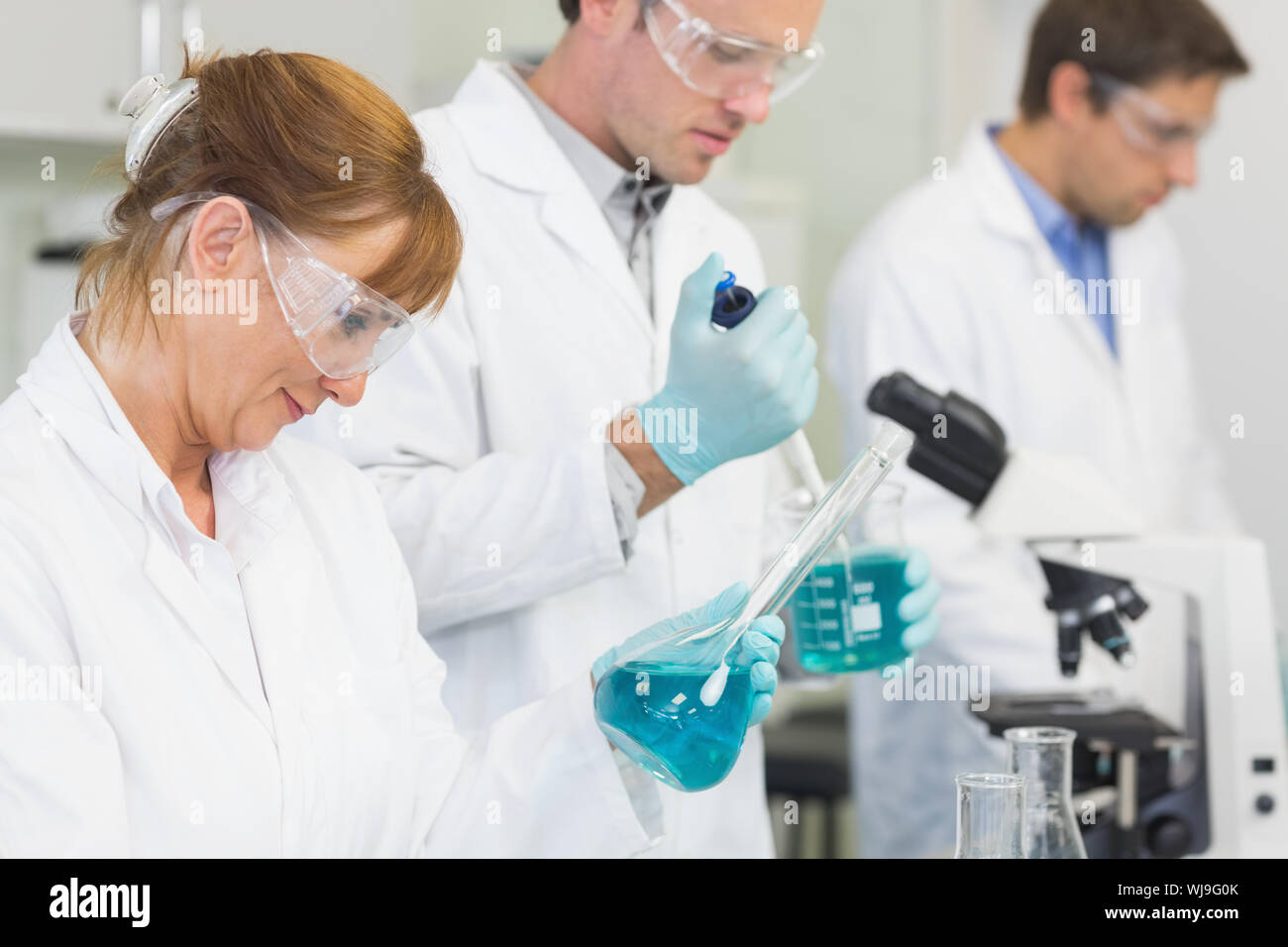 Focused scientist examining liquid in hi-res stock photography and ...