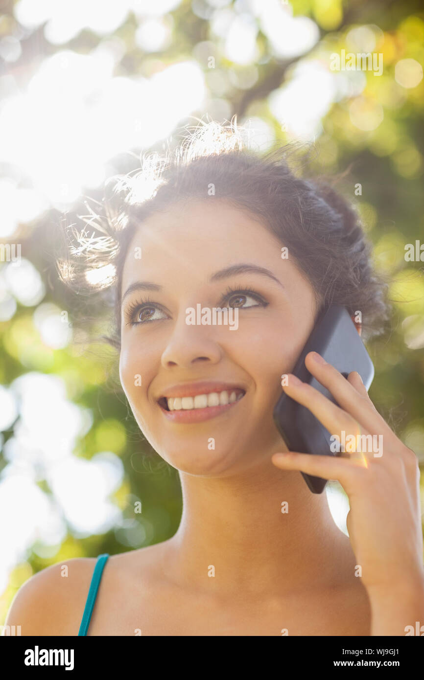 Cheerful young woman calling with her smartphone in a park Stock Photo ...