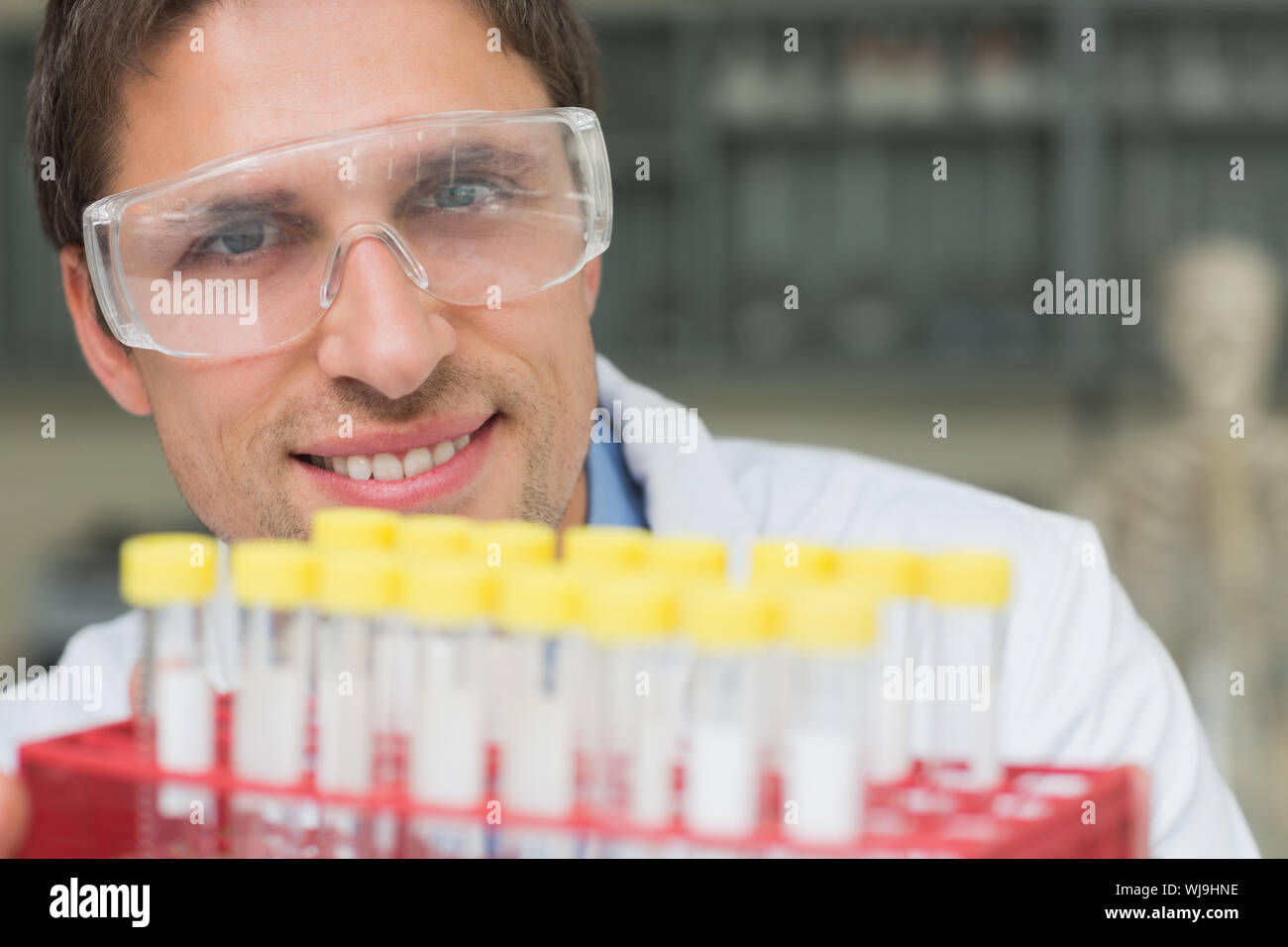 Extreme close-up portrait of a male researcher with at test tubes in ...