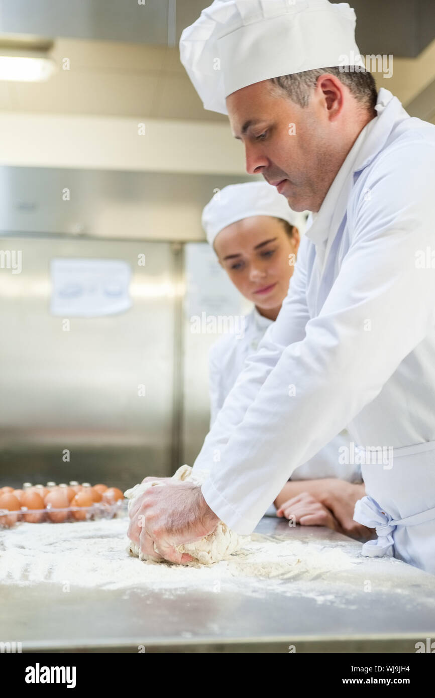 Focused head chef kneading dough in professional kitchen Stock Photo ...
