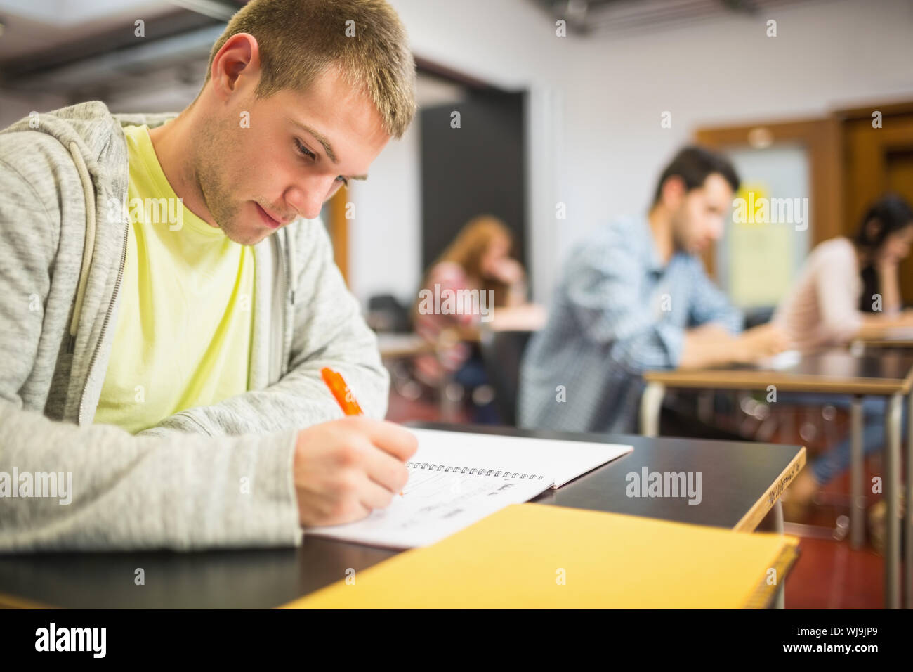 Group of young students writing notes in the classroom Stock Photo - Alamy