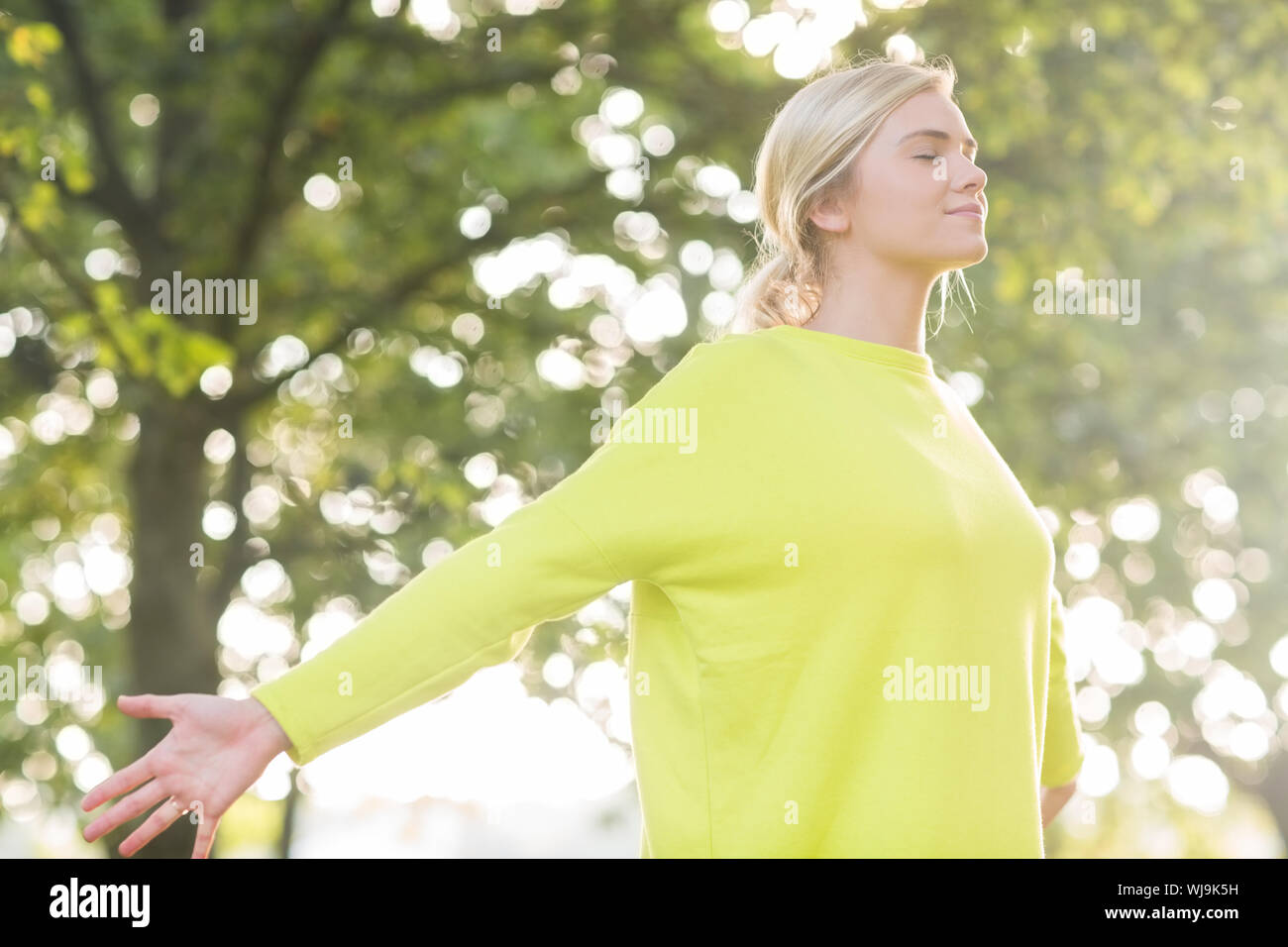 Fit happy blonde enjoying the sun in a park on a sunny day Stock Photo ...