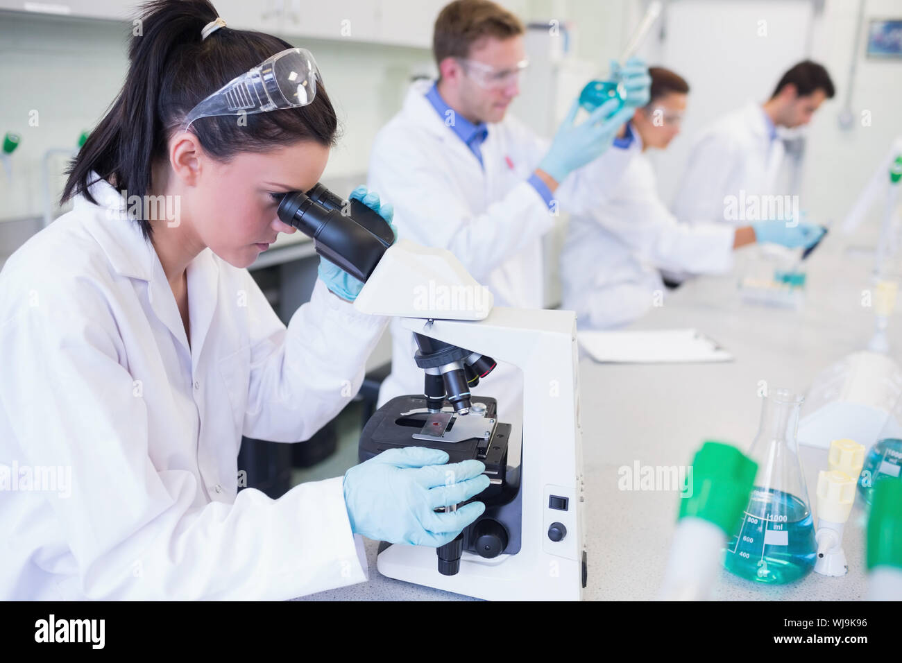 Side view of busy group of researchers working on experiments in the ...
