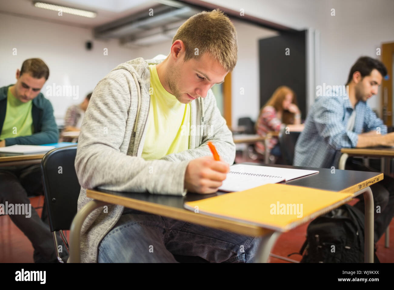 Group of young students writing notes in the classroom Stock Photo - Alamy
