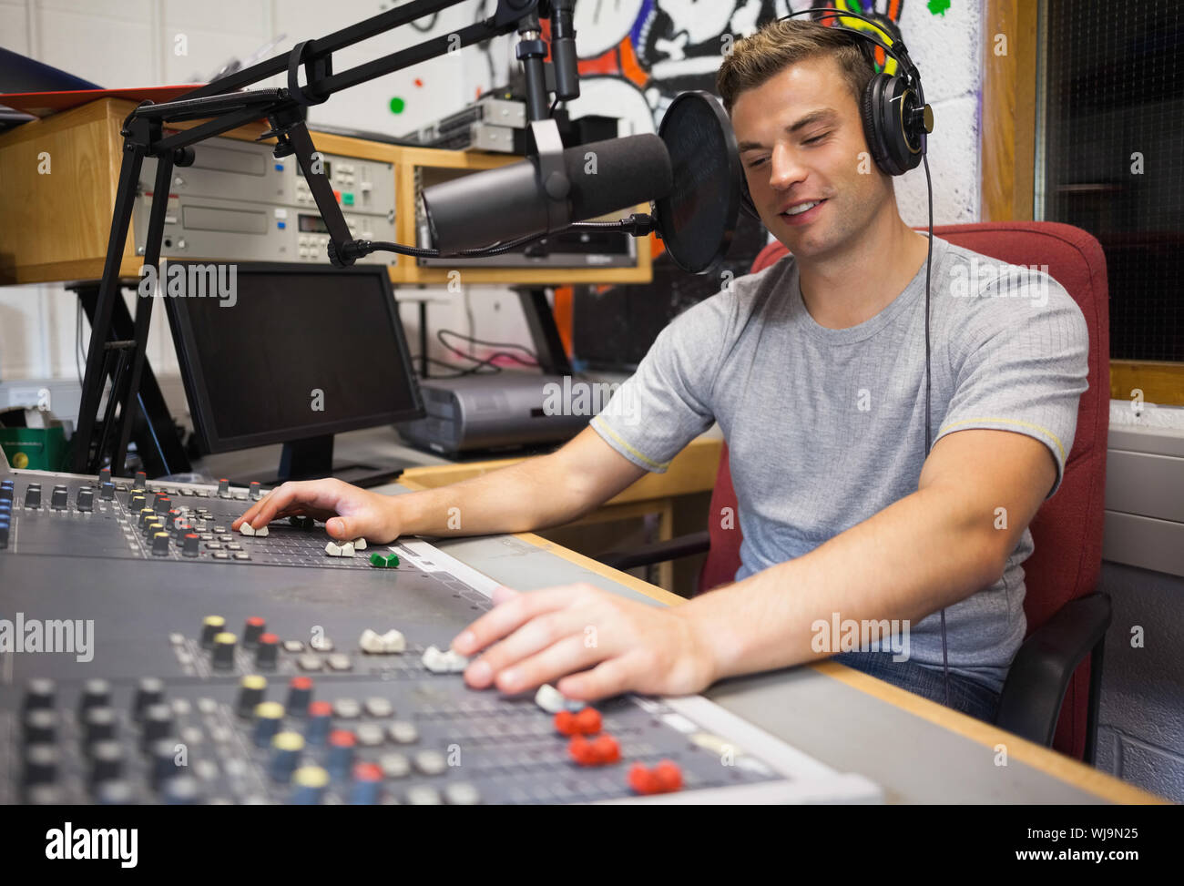 Handsome happy radio host moderating in studio at college Stock Photo ...