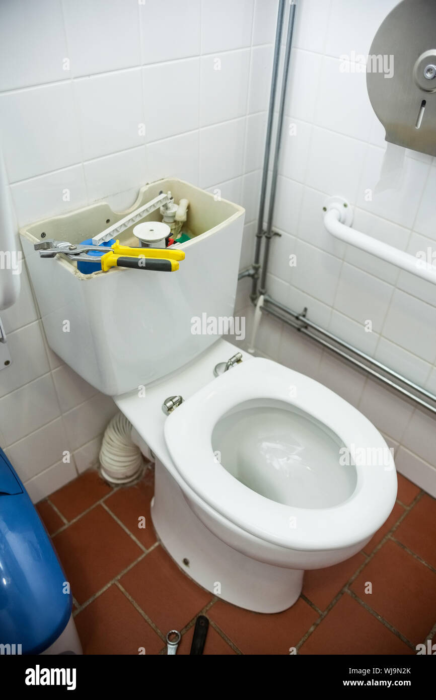 Close up of pliers lying on open toilet in public bathroom Stock Photo ...