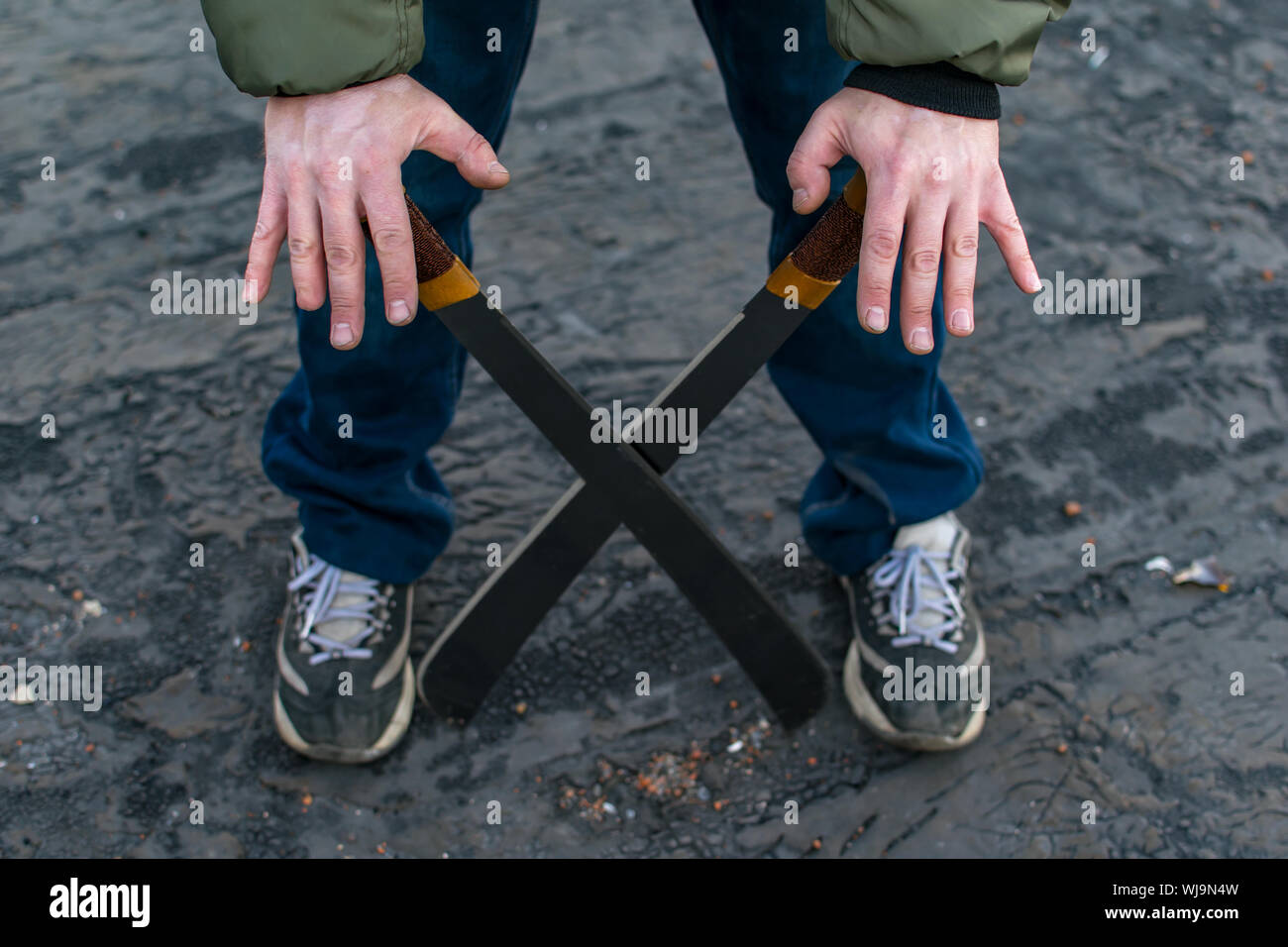 Crossed machetes in human hands Stock Photo - Alamy