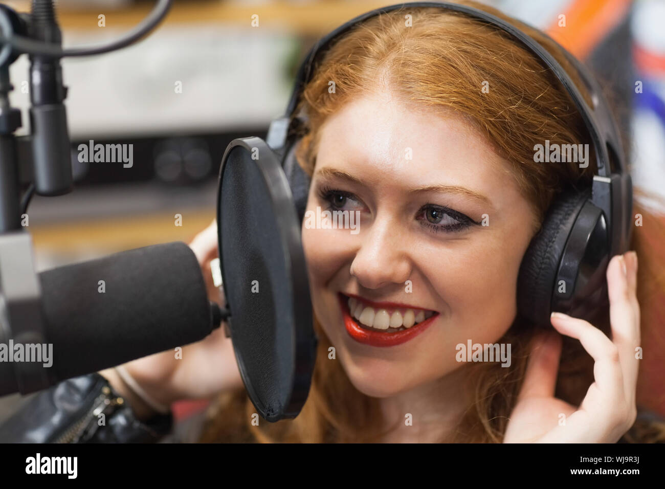 Happy beautiful singer recording a song in studio at college Stock ...