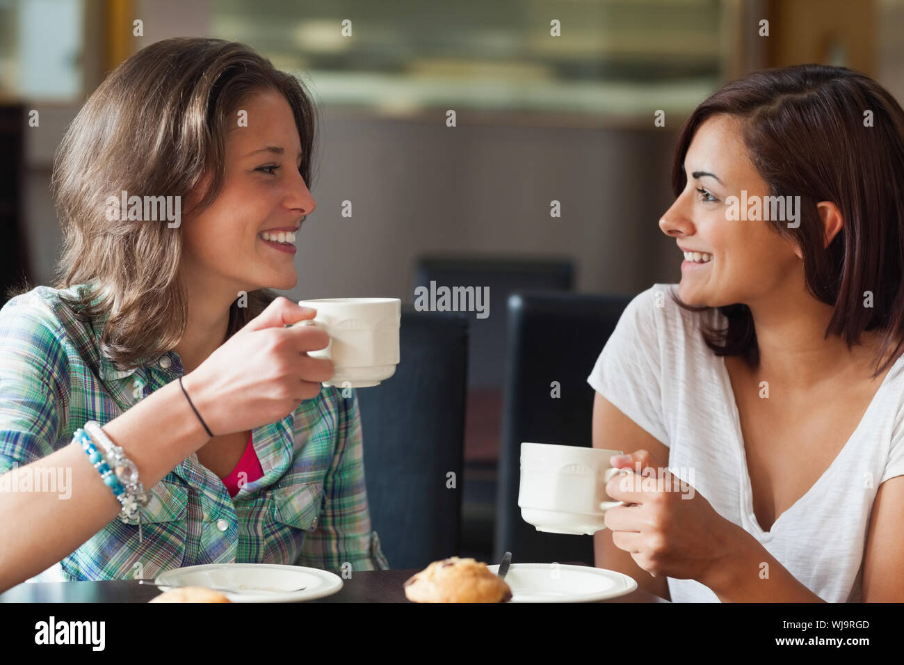 Two smiling students having a cup of coffee in college canteen Stock ...