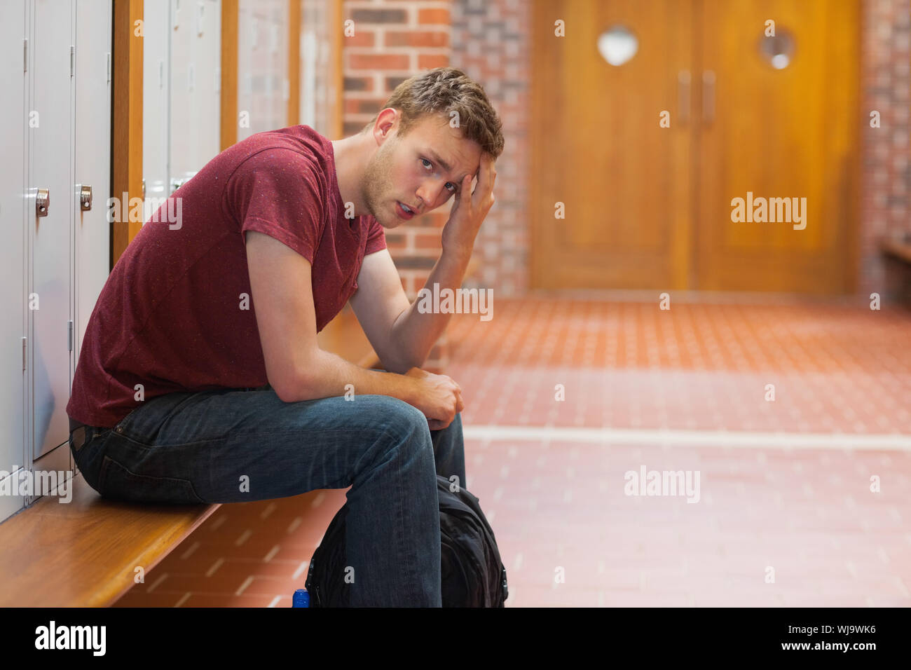 Frowning handsome student having a headache in school Stock Photo - Alamy