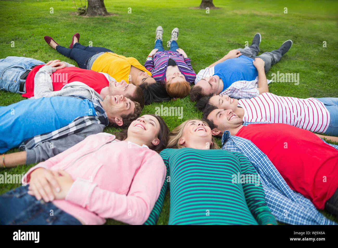 High angle view of a group of friends laying in a circle at park Stock ...